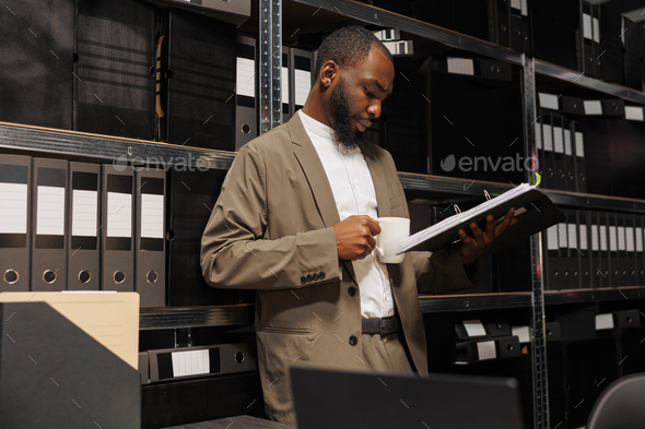 Cop drinking coffee and reading investigation report file Stock Photo ...