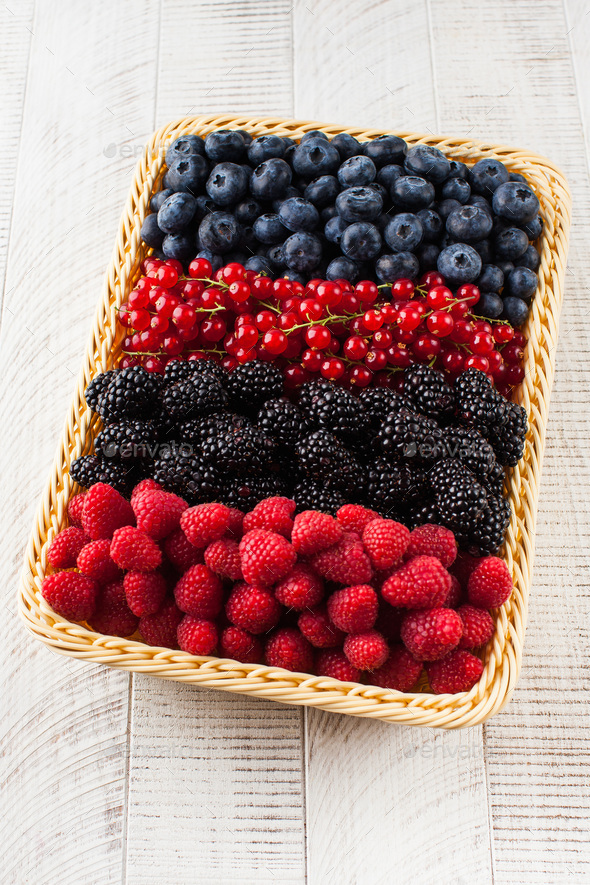 Assorted different types of ripe wild berries in a basket. berries ...