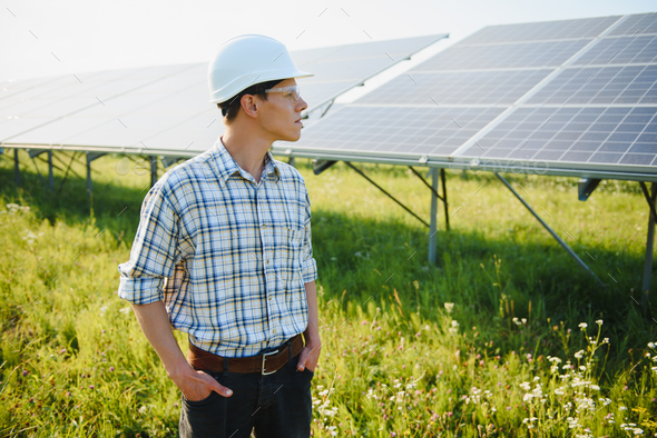 Solar power plant. Man standing near solar panels. Renewable energy ...