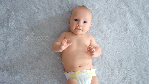 A healthy newborn baby in a nappy without clothes. Cute baby with blue ...