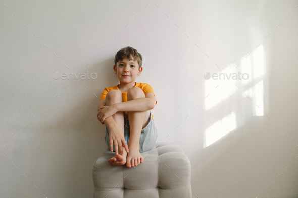 Cute boy sitting barefoot in a home. Beautiful light. Stock Photo by ...