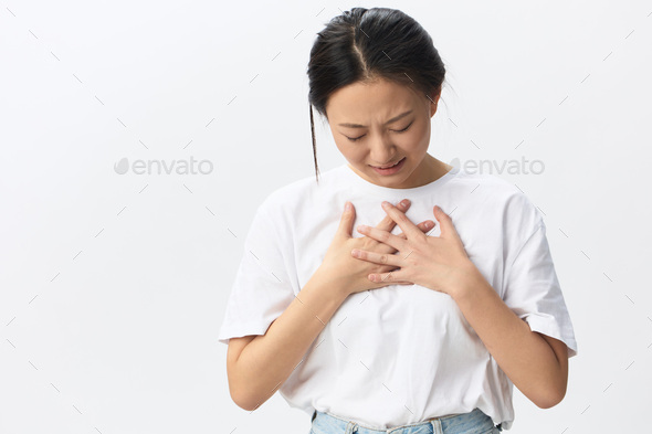 Heart attack. Suffering from pain tanned beautiful young Asian woman ...