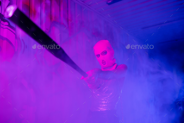 provocative woman in balaclava holding baseball bat in outstretched ...