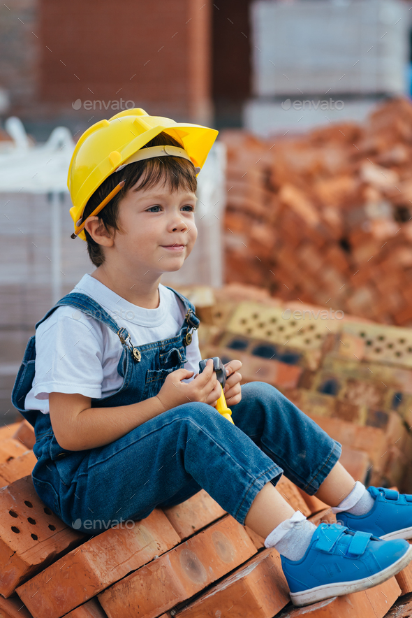 Architect in helmet writing something near new building. boy on the ...