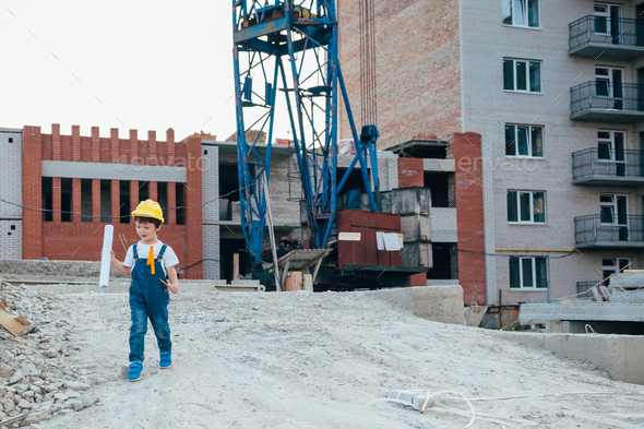 Architect in helmet writing something near new building. boy on the ...