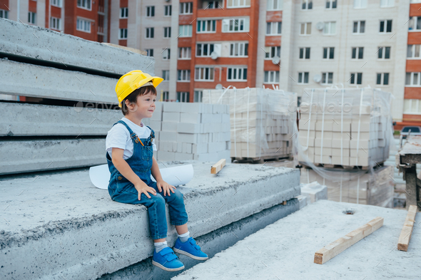 Architect in helmet writing something near new building. boy on the ...