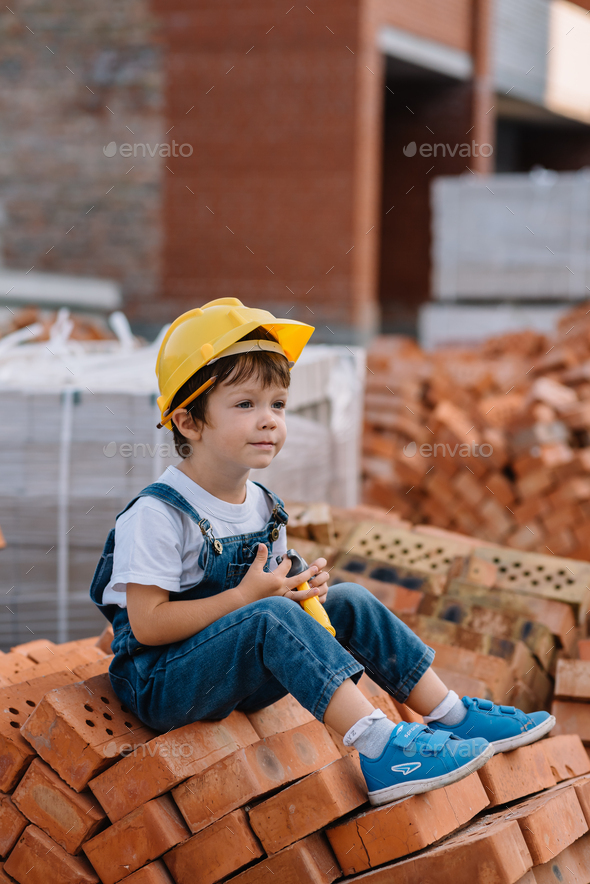 Architect in helmet writing something near new building. boy on the ...