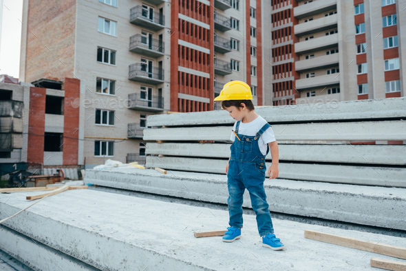 Architect in helmet writing something near new building. boy on the ...