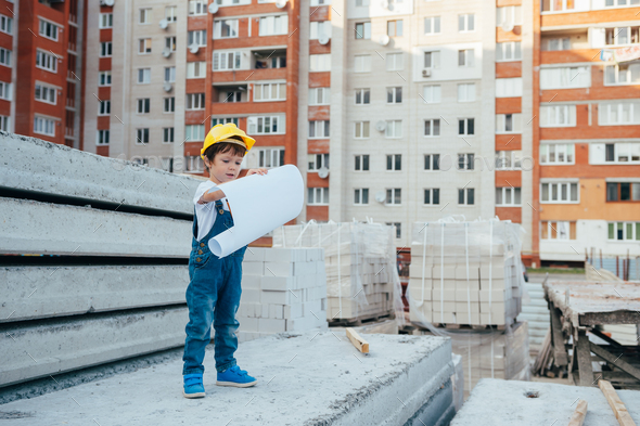 Architect in helmet writing something near new building. boy on the ...
