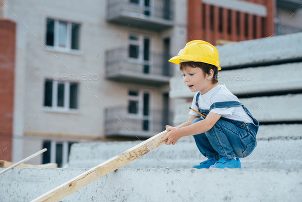 Architect in helmet writing something near new building. boy on the ...