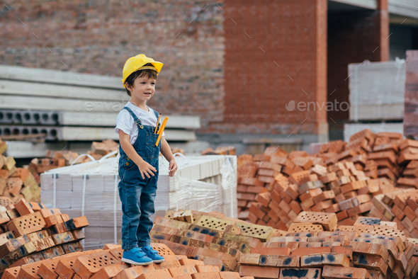 Architect in helmet writing something near new building. boy on the ...
