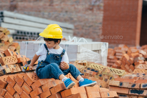 Architect in helmet writing something near new building. boy on the ...
