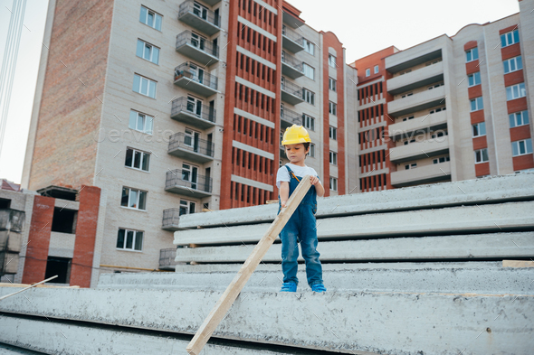 Architect in helmet writing something near new building. boy on the ...