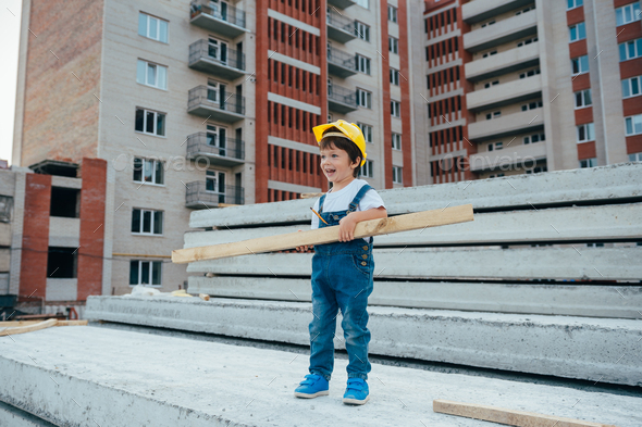 Architect in helmet writing something near new building. boy on the ...