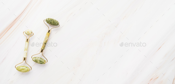 SPA concept. Two green face rollers from natural jade stone on a light ...