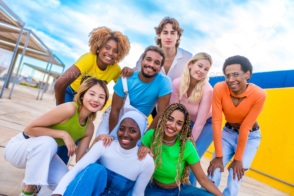 Young multicultural people crouching and posing outdoors Stock Photo by ...