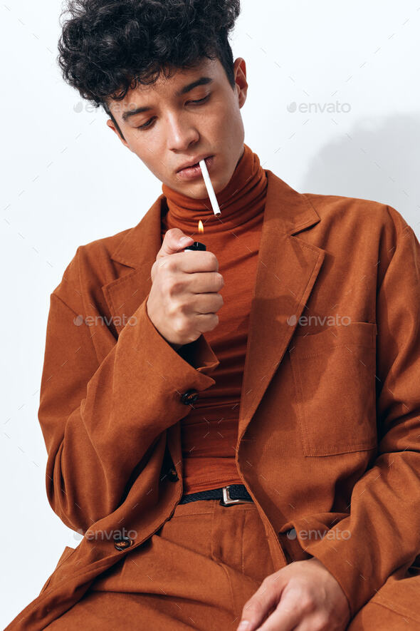Fashion man smoking sitting cigarette portrait background beige Stock ...