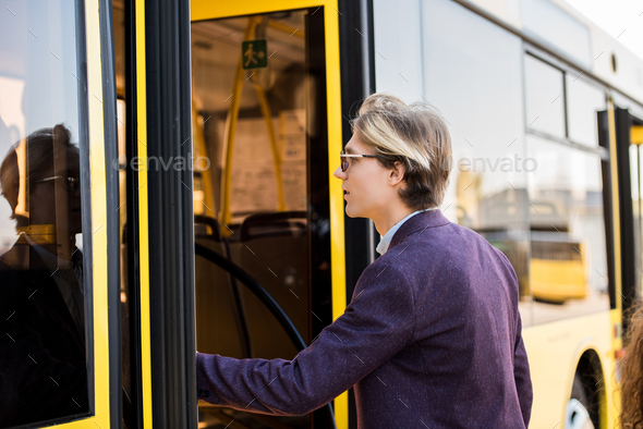 side view of handsome young man in eyeglasses entering city bus Stock ...
