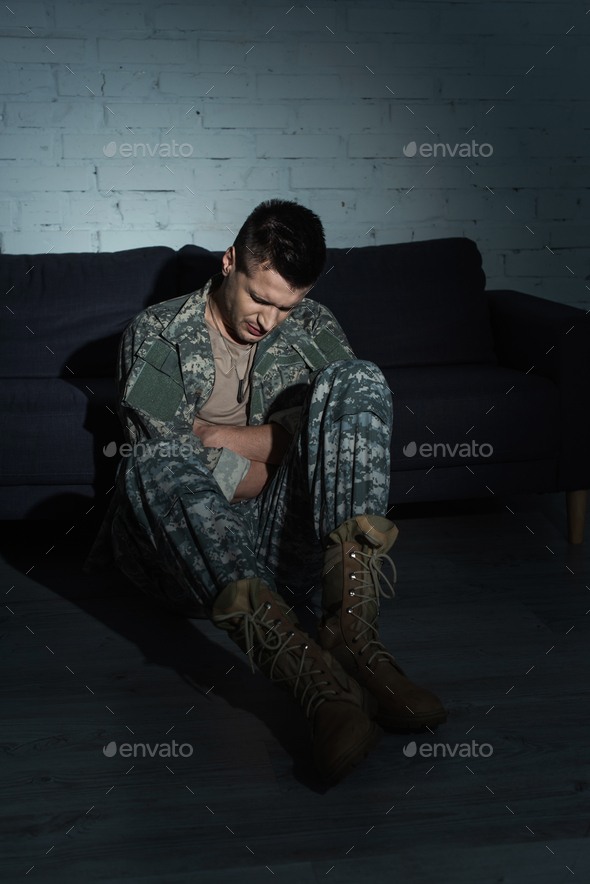 depressed serviceman in military uniform suffering from post traumatic ...