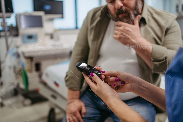 Doctor checking blood glucose level using a fingerstick glucose meter ...