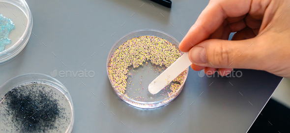 Female scientist hands taking sample of small plastic particles from ...