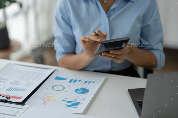 Businesswoman using calculator to check company finances income and ...