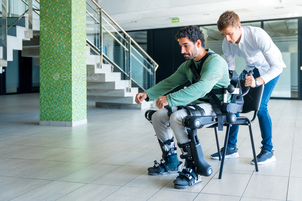 Mechanical exoskeleton, physiotherapist helped disabled person get up ...