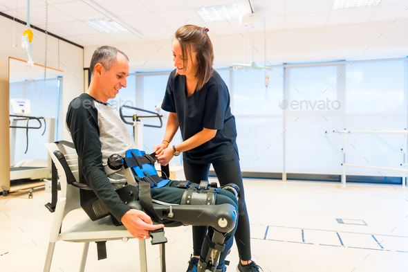 Mechanical exoskeleton. Physiotherapy assistant placing tapes on ...