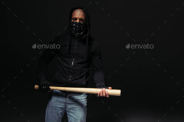 African american hooligan in gloves and mask on face holding baseball ...