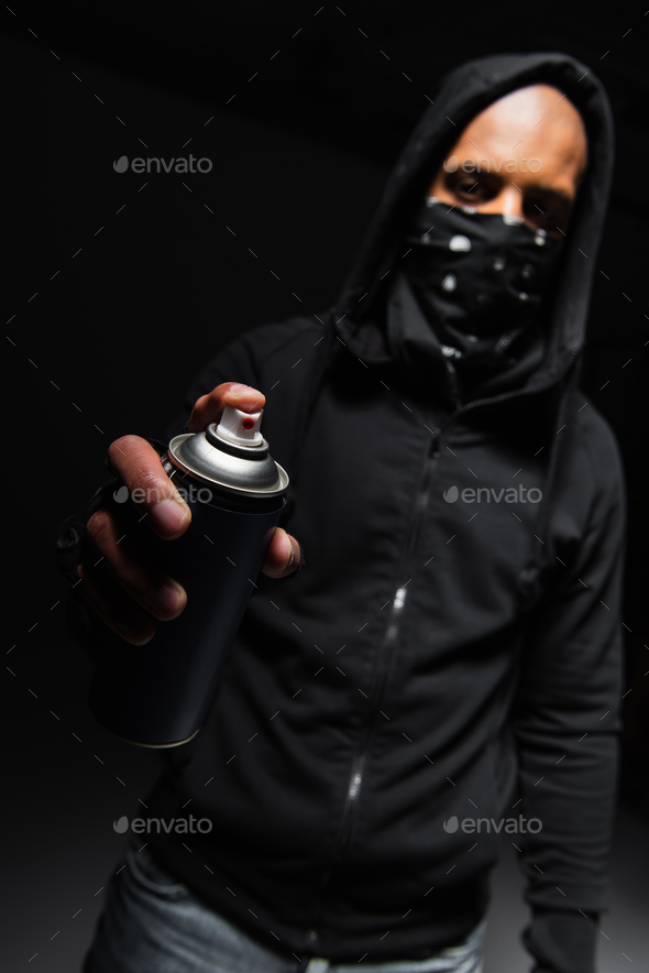 Blurred african american hooligan with mask on face holding spray paint ...