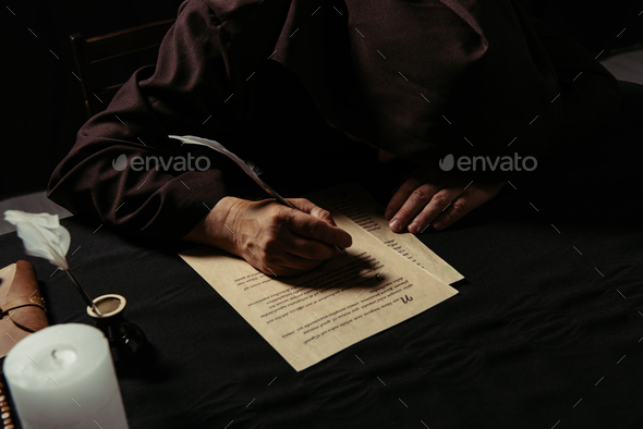 medieval monk with bowed head writing manuscript on parchment isolated ...