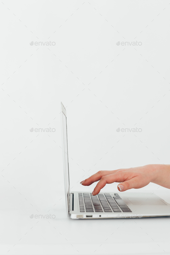 Female hand carefully typing buttons on the laptop keyboard, side view ...