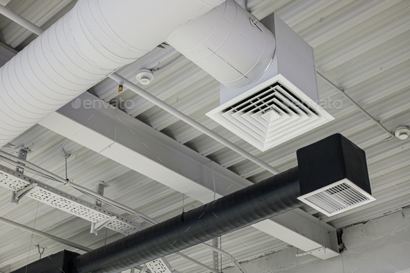 Two ventilation duct systems with grilles under ceiling in commercial ...