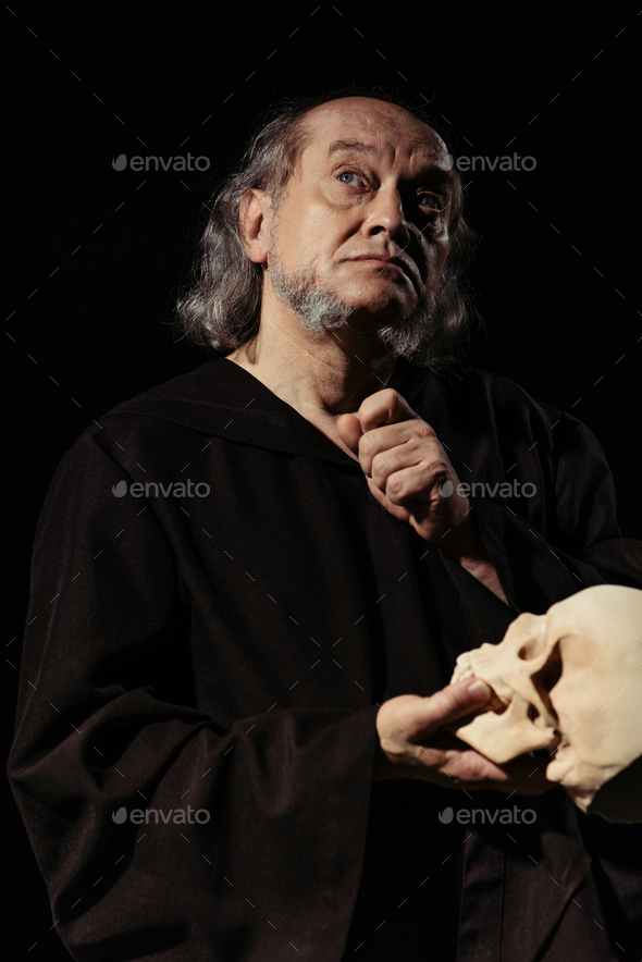 medieval religious philosopher with skull looking up while thinking ...