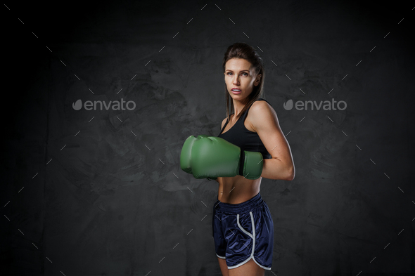 Female fighter in sports bra and boxing gloves showcases striking ...