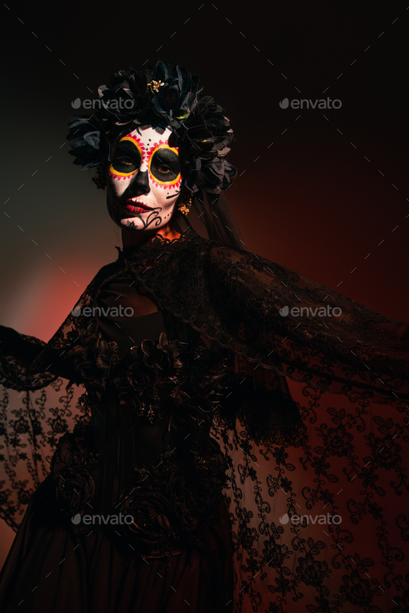 Woman in traditional mexican santa muerte costume looking at camera on ...
