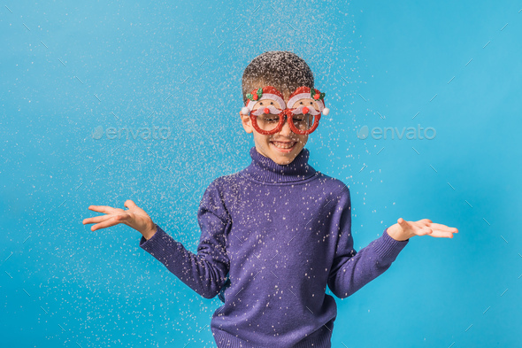 Child boy throws up on blue background. Christmas and New Year holidays ...