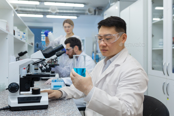 Serious thinking asian scientist working with microscope inside ...