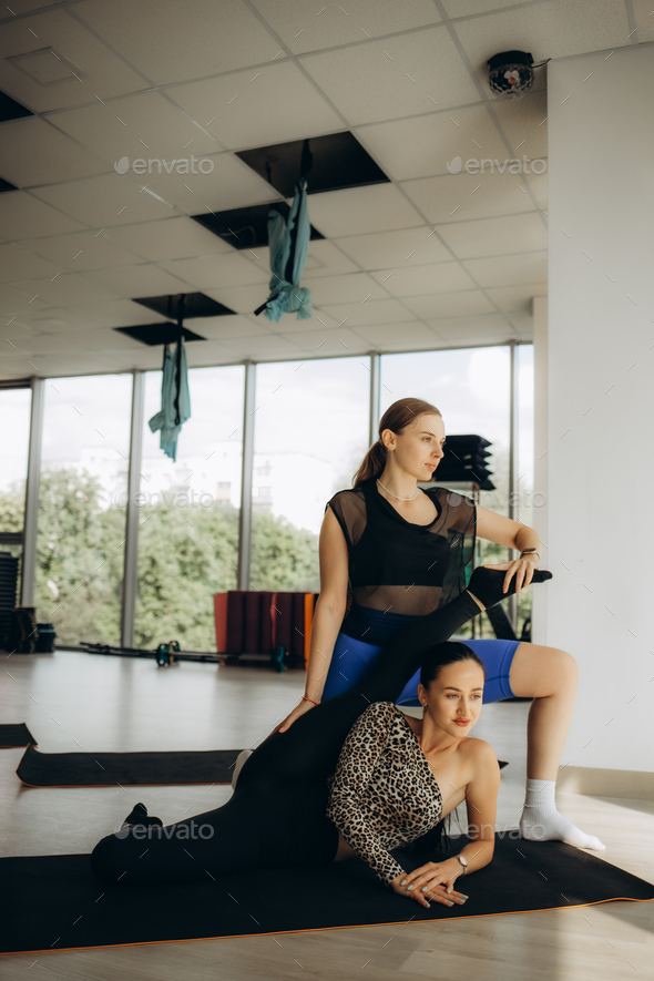 Group fitness class. Coach training girls in the gym showing the ...