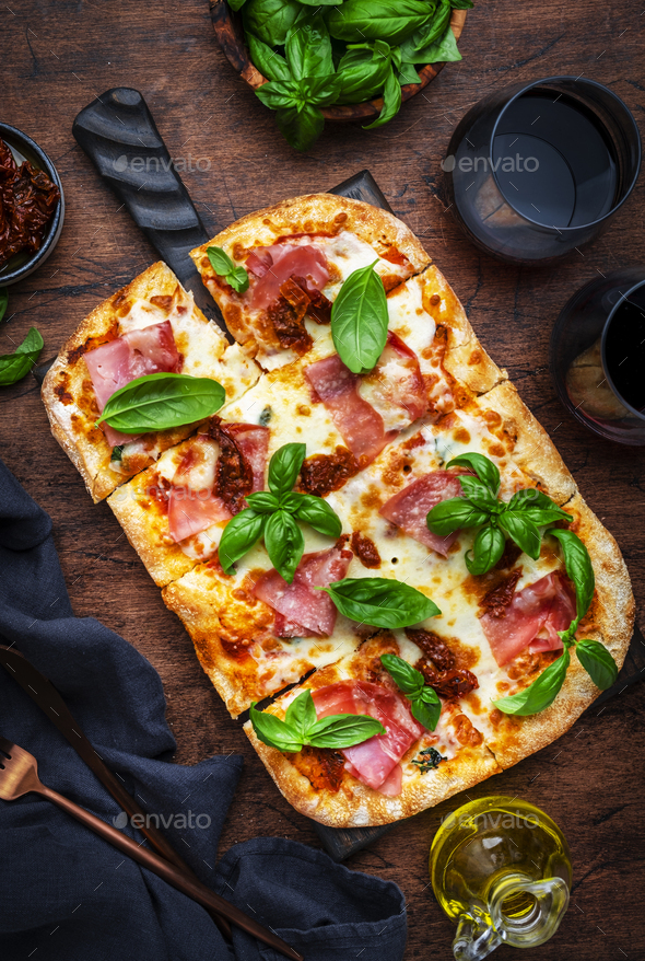 Rectangular roman pizza with smoked ham, mozzarella cheese, sun dried ...