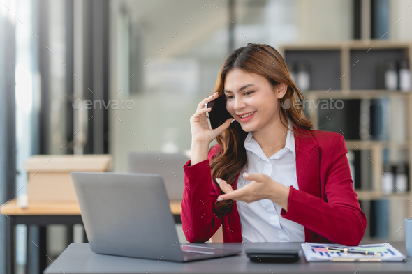 Young businesswoman making a professional phone call in her office ...