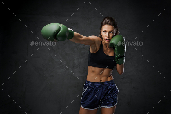 Female fighter in sports bra and boxing gloves showcases striking ...