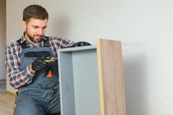 Professional Furniture Assembly Worker Assembles Shelf. Stock Photo by ...