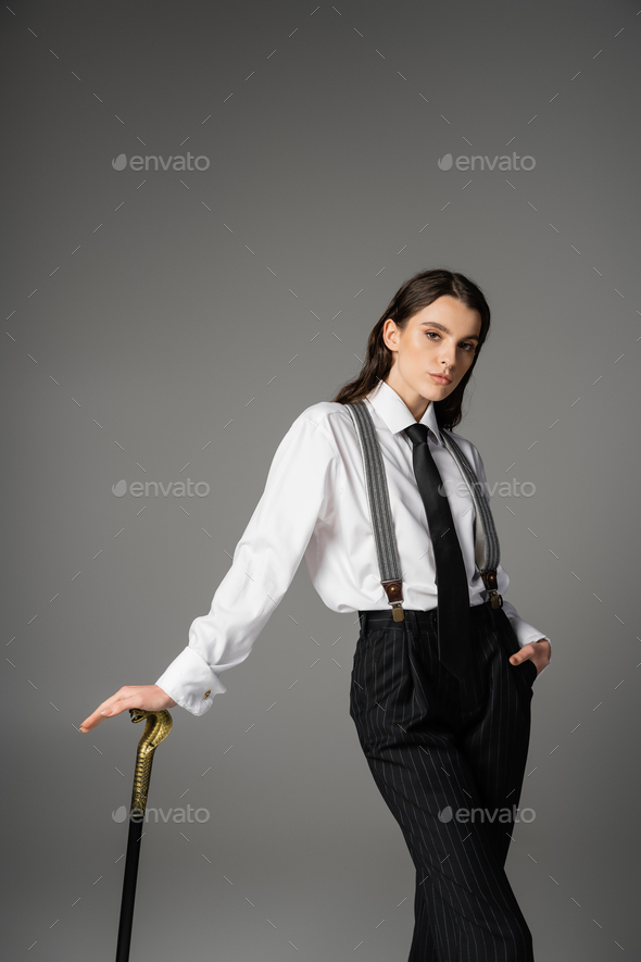 pretty brunette model in white shirt and tie posing with walking cane ...