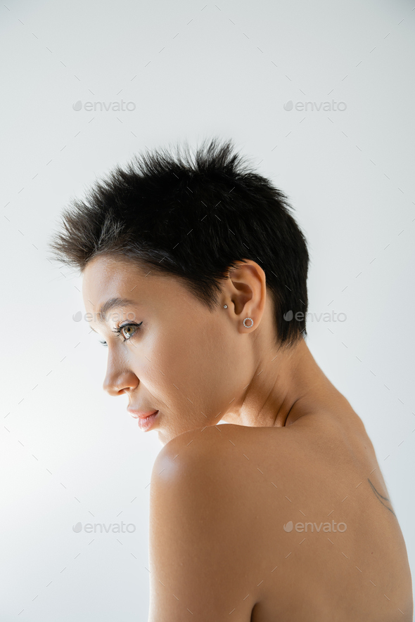 profile of brunette woman with short hair and bare shoulder looking ...