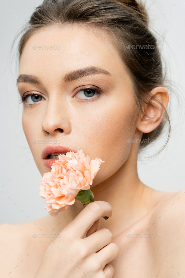 pretty woman with natural makeup and perfect skin holding carnation ...