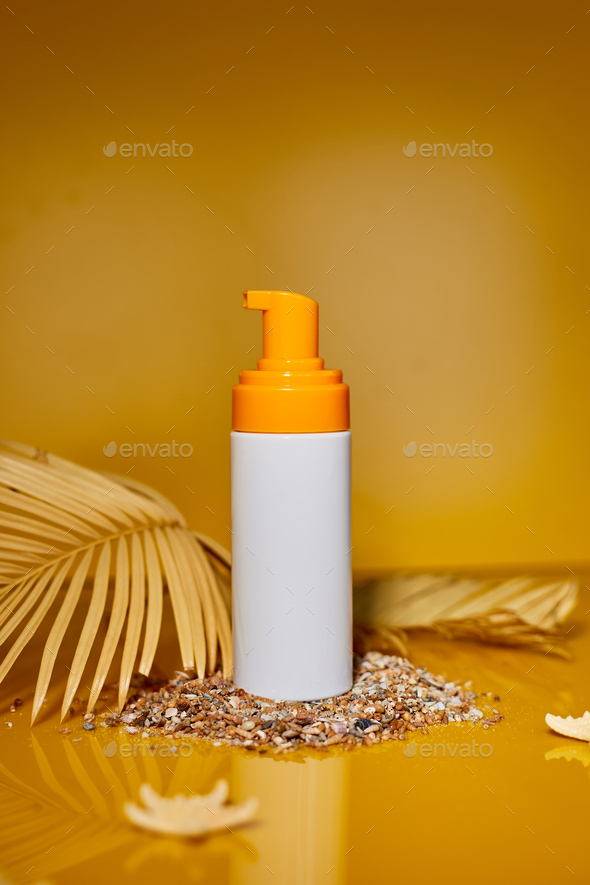 Sunscreen tube mockup with shells, sand yellow background Stock Photo ...