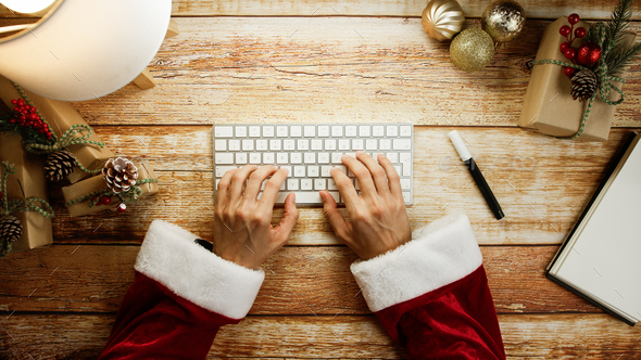 Santa working for Christmas on his desk at pc Stock Photo by PolonioVideo