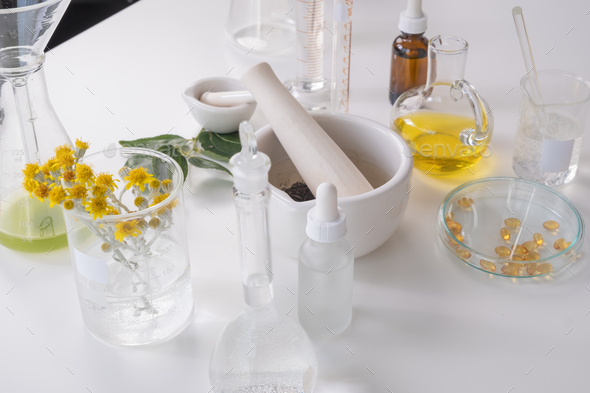 Laboratory equipment with herb, natural oil, and pestel and mortar for ...
