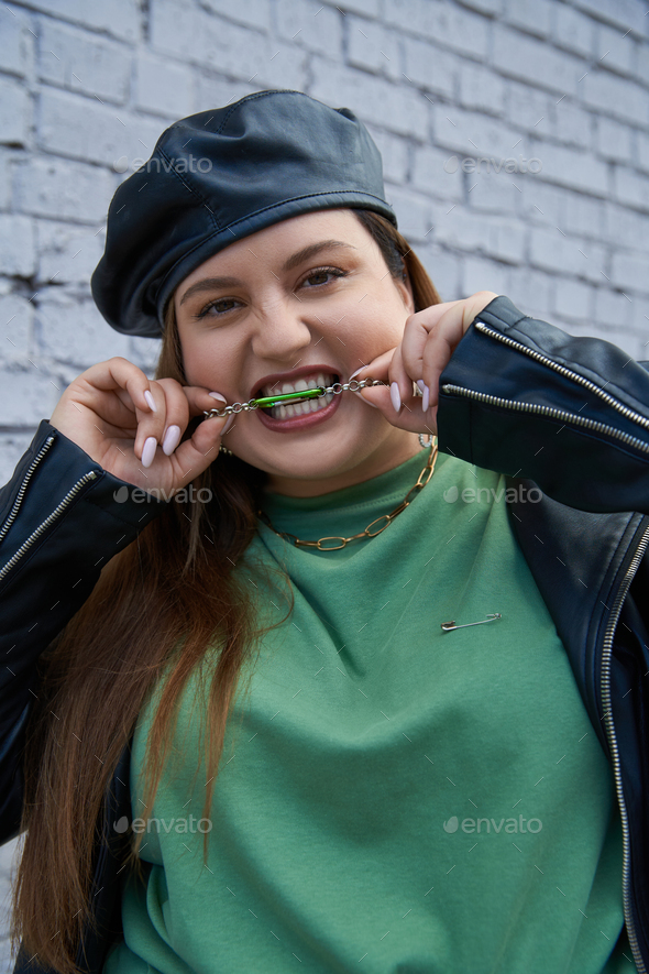 portrait of stylish plus size woman in leather jacket and black beret ...